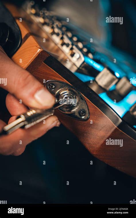Closeup Of Male Fingers Plugging Cable Into Input Jack Of An Electric