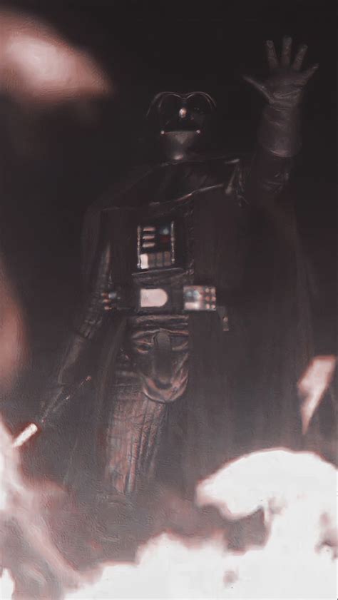 A Man Dressed As Darth Vader Standing In Front Of A Bunch Of Fire
