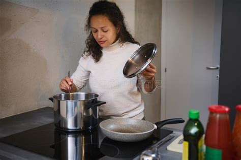 Woman Cooking In Modern Kitchen Stirring Ingredients In Pot Stock
