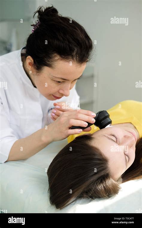 Female Dermatologist Using A Professional Dermatoscope While Doing Skin