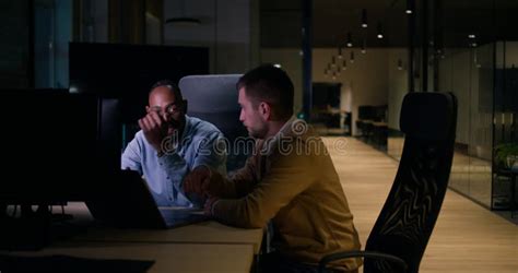 Focused Multicultural Team Collaborating Late At Night Analyzing Data