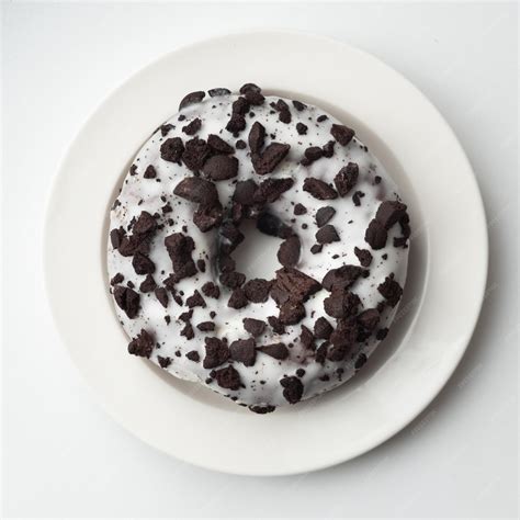 Premium Photo A Donut With White Icing And Chocolate Chips On A Plate