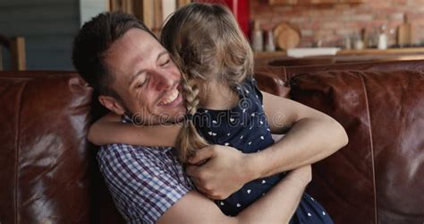 Happy Dad His Daughter Embracing Tightly Seated On Sofa Indoor Stock