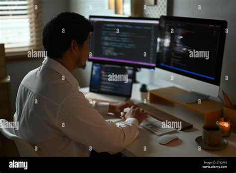 skilled male programmer working with coded data on computer screen in