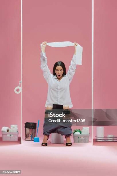 Emotional Business Woman Sitting On Toilet Raising Toilet Paper Upwards