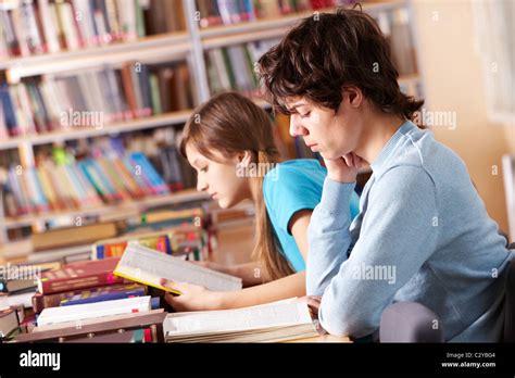 Portrait Of Serious Guy Reading Book With His Classmate On Background