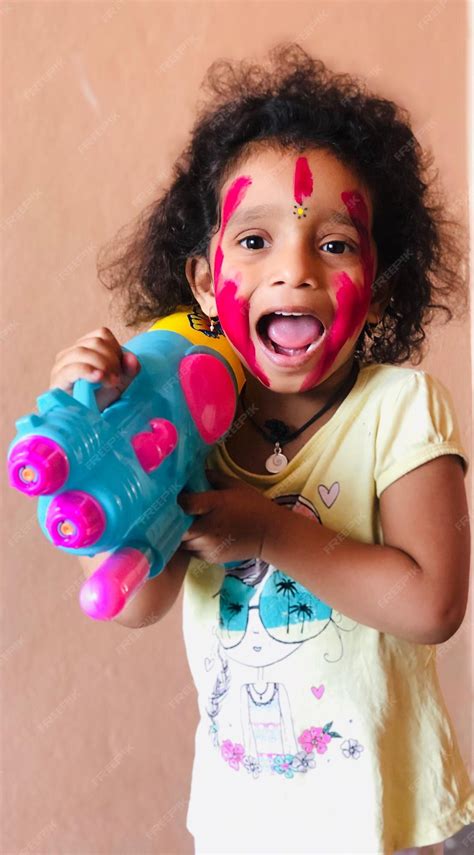 Premium Photo Cute Girl Screaming While Holding Squirt Gun Against