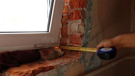 measuring the depth of a window opening with a tape measure for making