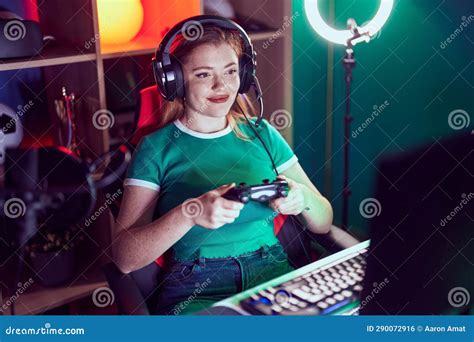 Young Redhead Woman Streamer Playing Video Game Using Joystick At