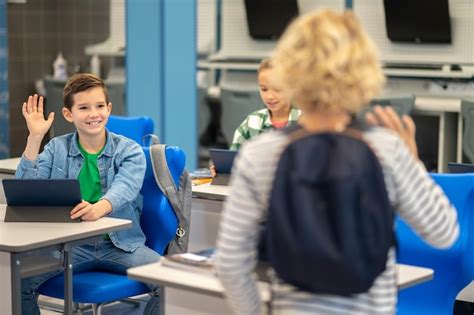 Premium Photo Boy With Back To Camera Greeting Classmates