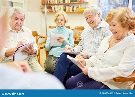 Adultos Mayores En Terapia De Grupo Mientras Escriben Foto De Archivo