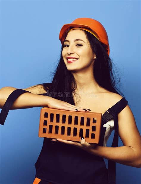 Brunette Builder On A Blue Background With An Electric Tool In The