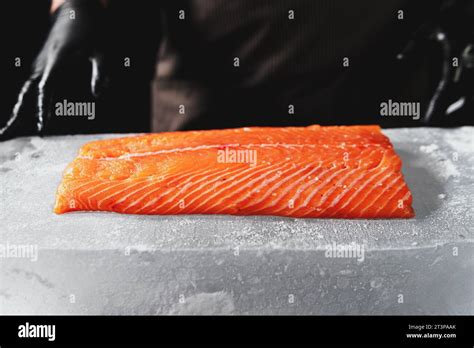 Close Up Of Chef Hand Prepared To Cooking Fresh Salmon Fillet Black