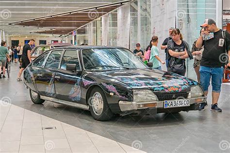 A Sleek Angular Car Sits Indoors With Its Hood Propped Open Showcasing Its Engine Bay The