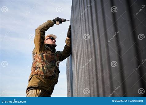 Builder Installing Corrugated Iron Sheet Used As Facade Of Future Wooden Frame House Stock