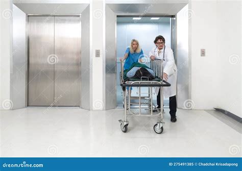 Paramedic And Nurse Pushing The Patient Bed Out Of The Elevator To The Emergency Room Of The