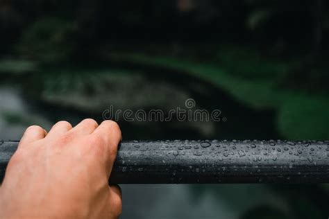 Left Hand Of A Young Caucasian Person Holding Tightly To The Metal And