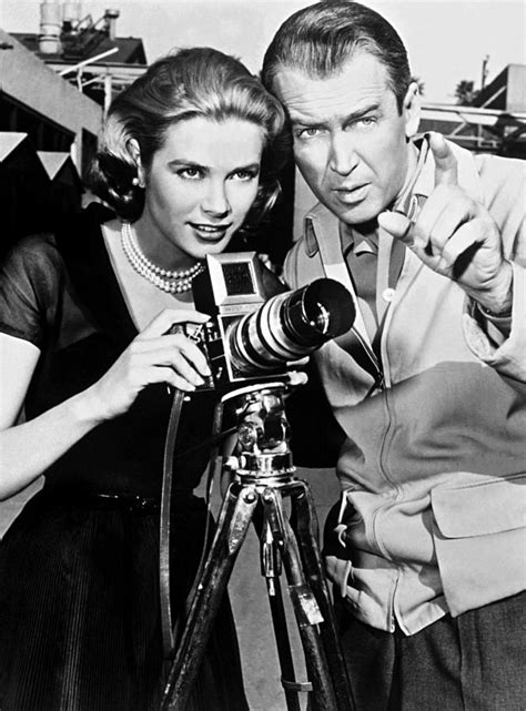 James Stewart And Grace Kelly Looking Away While Adjusting Camera