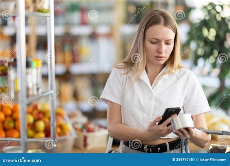 Female Shopper Scanning Qr Code Or Barcode On Tin Can Label In Grocery