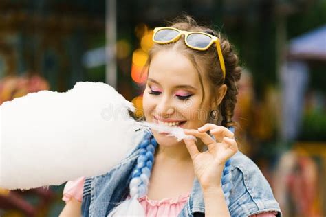 Funny Young Girl Eats Cotton Candy On A Sunny Day At An Amusement Park Stock Image Image Of