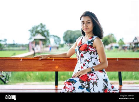 That Woman Sat On A Wooden Terrace And Laid Her Hands On Her Legs Stock