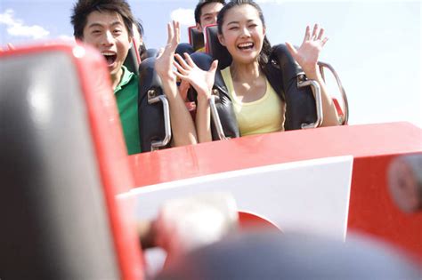 东方人四个人游乐园坐笑微笑露齿笑横图室外白天正面时尚游戏快乐兴奋友谊幸福北京中国亚洲玩大喊休闲装