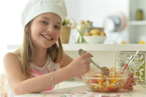 Premium Photo Portrait Of Cute Girl Eating Salad On Kitchen