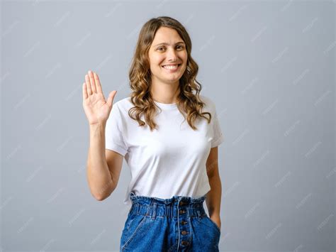 Premium Photo Portrait Of Friendly Woman Waiving Hand To Say Hi