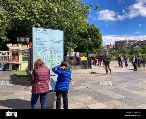Visitors Checking The Information Board With City Map And Attractions