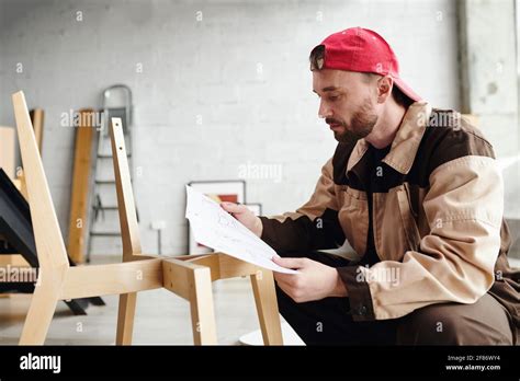 Contemporary Furniture Assemblage Specialist Looking Through Paper With