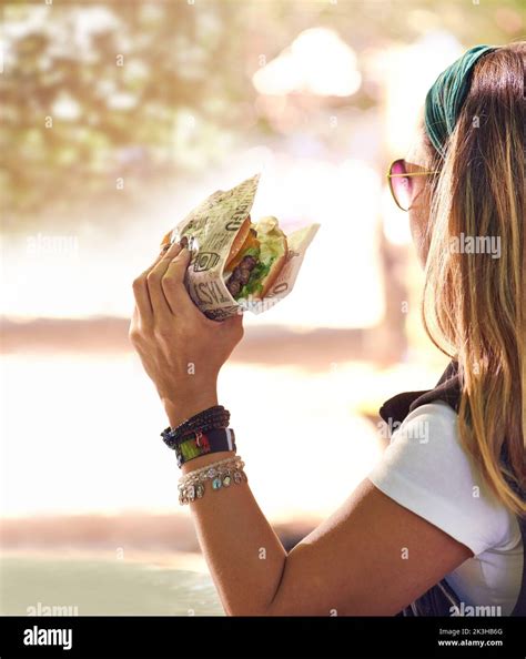 Time For Some Tasty A Young Woman Eating A Hamburger Outside Stock