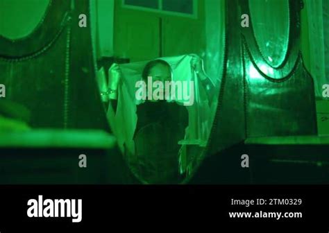 A Muslim Woman Opens A Head Covering In Front Of A Mirror And Dressing