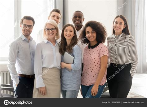 Happy Multicultural Work Team Looking At Camera Posing In Office
