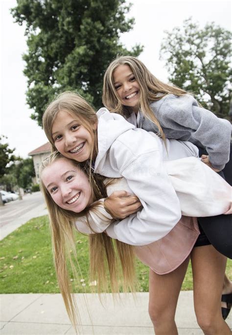 Group Of Teenage Girls Playing And Smiling Together Outdoors Stock