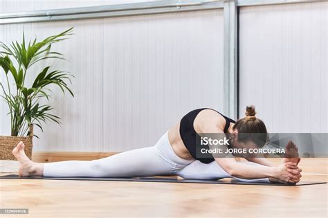 Portrait Of Female Athlete Performing Yoga Stretches In A Gym Stock