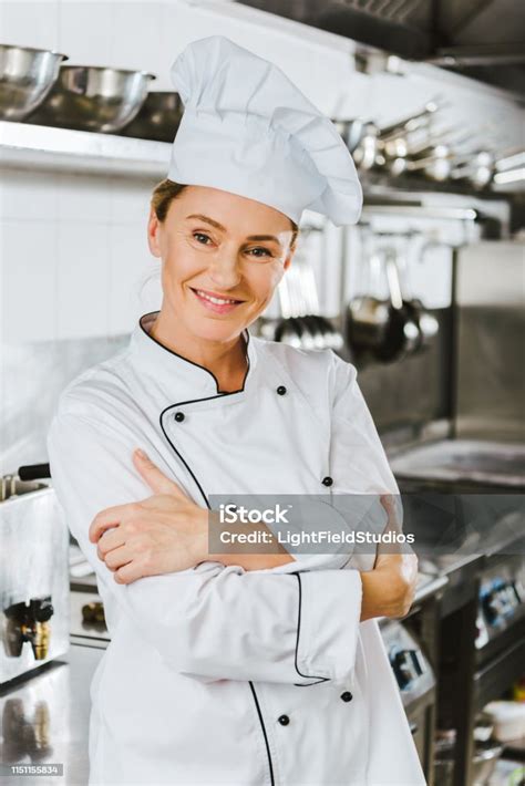 Koki Wanita Yang Menarik Berseragam Dengan Lengan Disilangkan Melihat Kamera Di Dapur Restoran