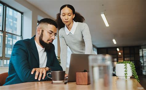 Two Young Business People Working On A Budget For A New Project With