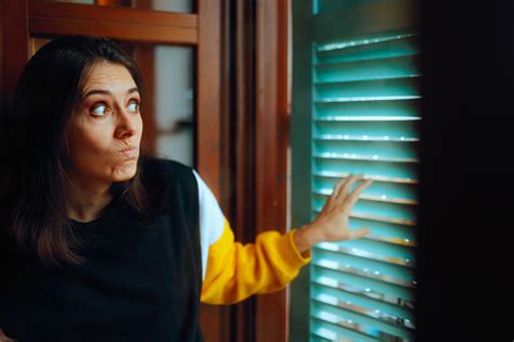 Curious Woman Spying On Her Neighbors Looking Through A Window Stock