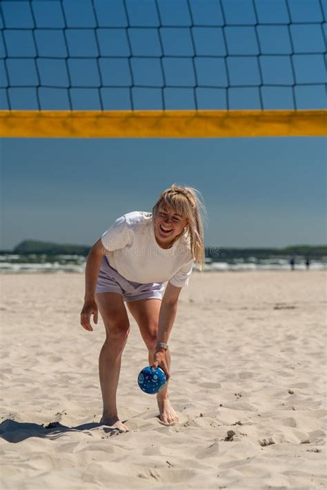 Happy Girl Playing Beach Volleyball Throwing Ball Over Net With Wide