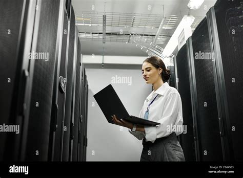 Woman In A White Shirt Works Diligently In A Modern Server Room