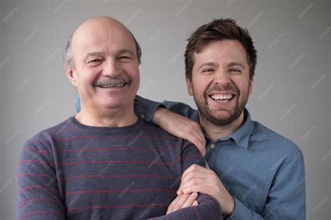 Premium Photo Smiling Senior Man With His Grown Up Son Smiling Having