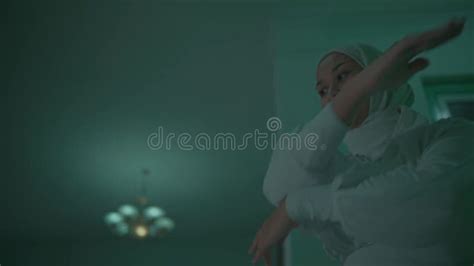 An Asian Female Dancer Dances In A Green Room With A Very Sad