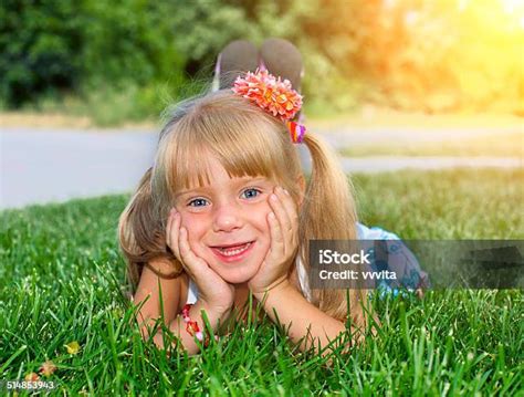 Foto De Menina Feliz No Parque Deitado Na Grama E Mais Fotos De Stock