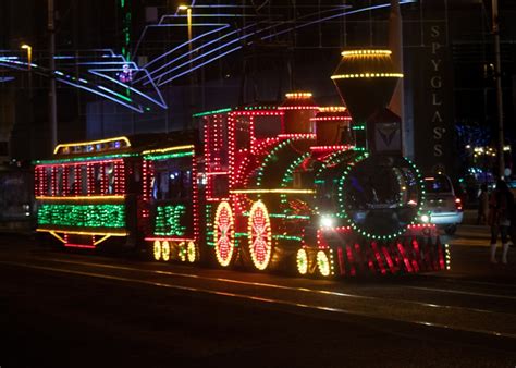 A Train Decorated With Christmas Lights On A City Street Photo Free Colours Image On Unsplash