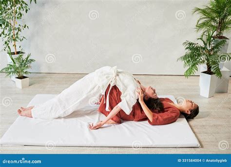 Masseuse Making Thai Yoga Massage Treatment Stretching Female Patient