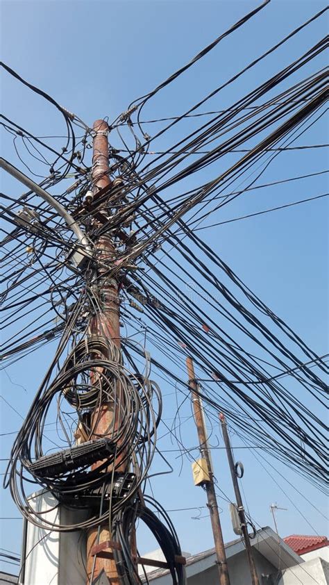 Chaotic And Tangled Mess Of Cables On A Utility Pole Highlighting Poor