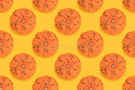 Repetitive Pattern Made Of Small Orange Pumpkin On A Yellow Background