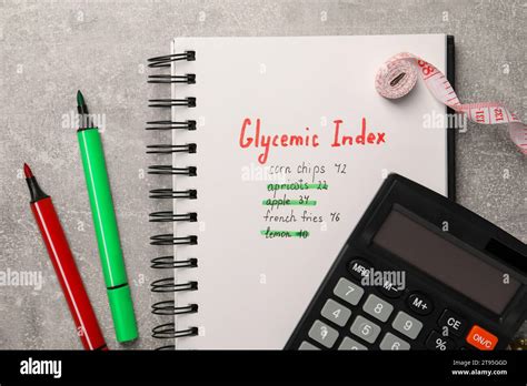 Glycemic Index Notebook With Information Markers Calculator And Measuring Tape On Light Grey Glycemic Index Notebook With Information Markers Calculator And Measuring Tape On Light Grey