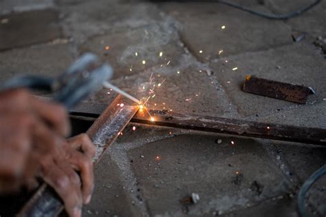 Premium Photo Person Welding Metal With Sparks In Workshop