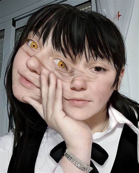 A Woman With Black Hair And Yellow Eyes Posing For The Camera